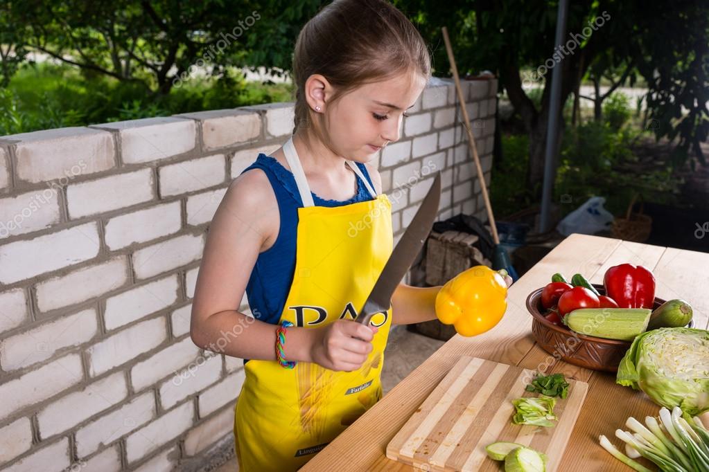 Young girl chopping vegetables Stock Photo by ©Vaicheslav 74803407
