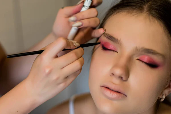 Make-up artist work on her friend. Real people. - Stock Image - Everypixel