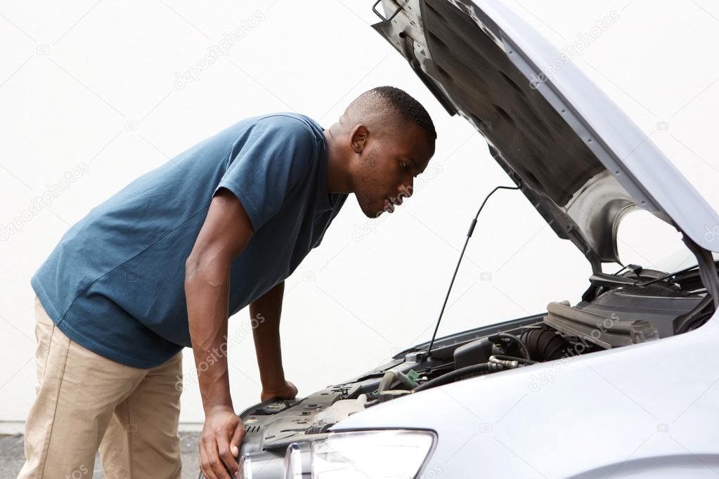 Guy looking under the hood of his broken down car Stock Photo by ...