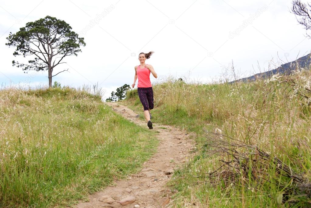 Woman running on dirt path Stock Photo by ©mimagephotos 109738536
