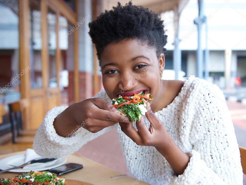 Happy african american woman eating pizza Stock Photo by ©mimagephotos ...