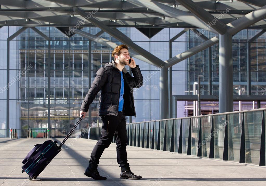 Man walking with suitcase and mobile phone at airport — Stock Photo ...