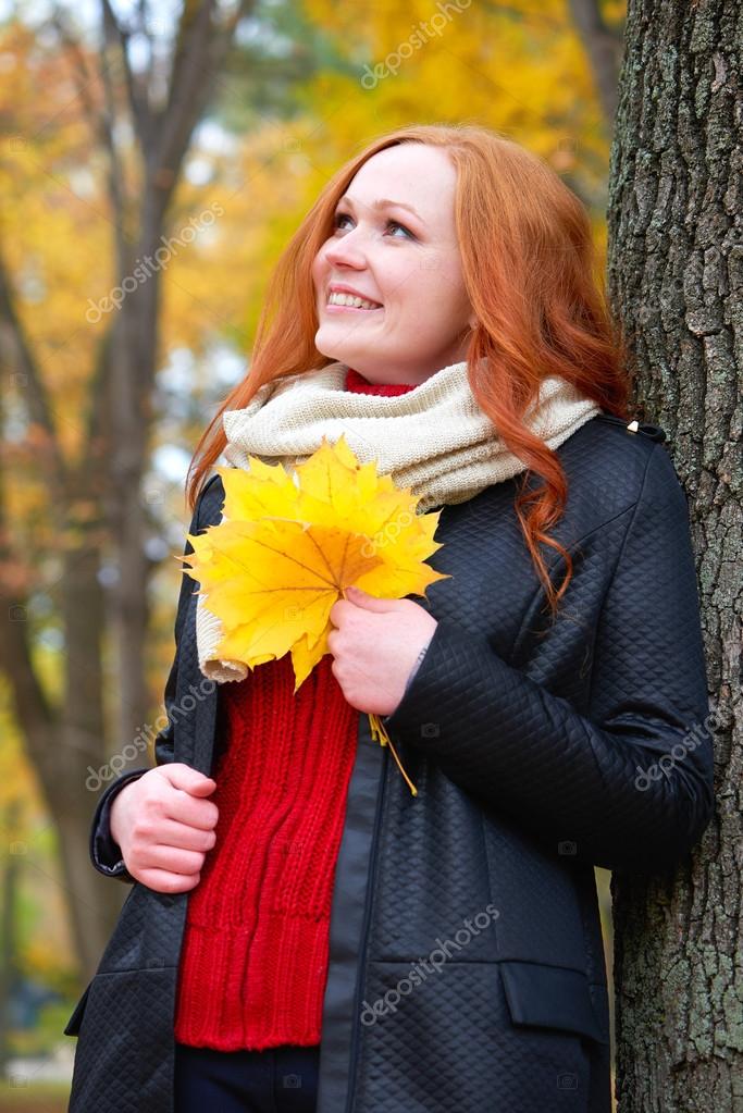 Girl Portrait With Yellow Leaf In Hand In Autumn Forest Stand Near Big
