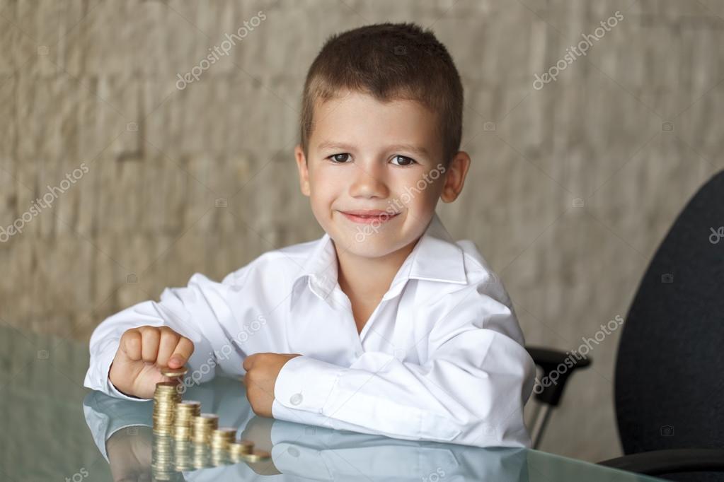 Niño contando monedas de un euro en la oficina 2022