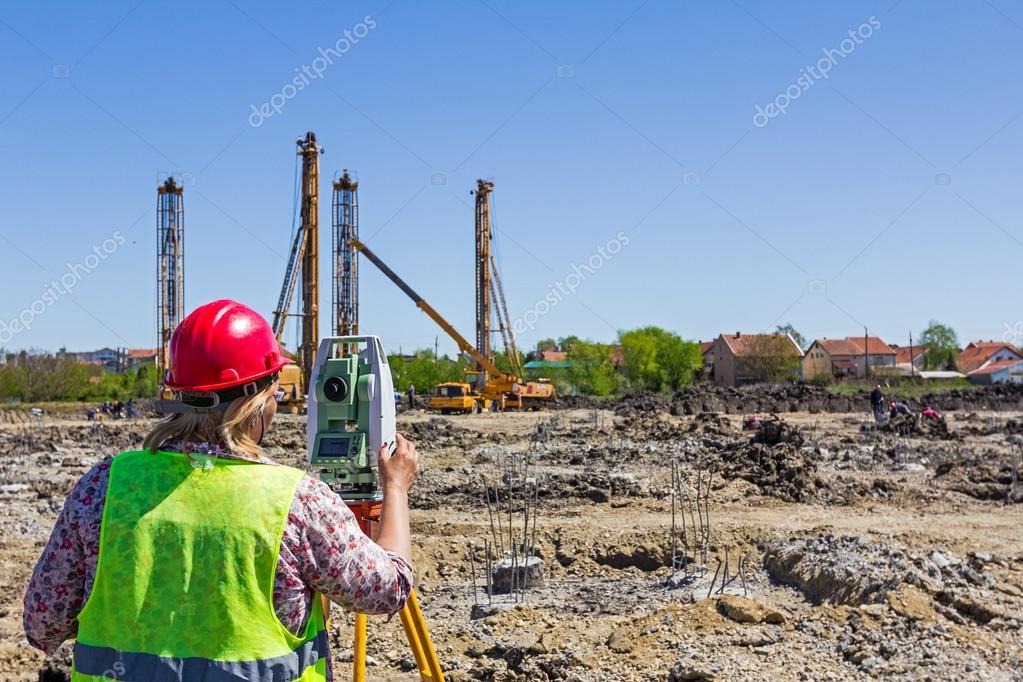 Female geodesist is working with total station on a building sit Stock ...