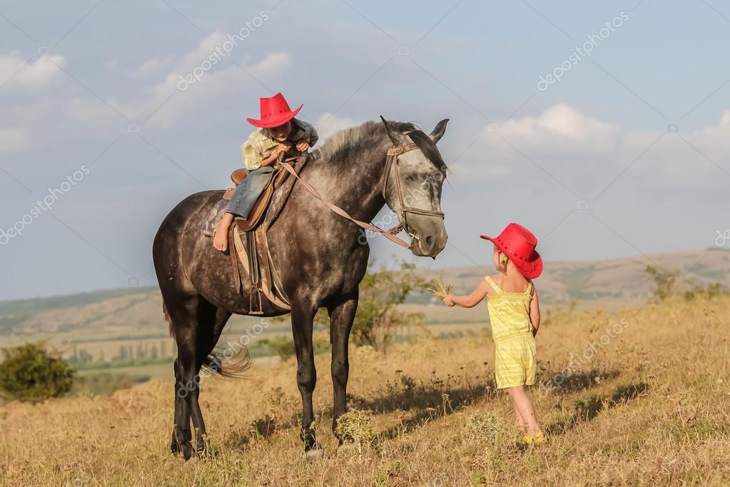 Two young happy kids riding a horse on farm, outdoor portrait on Stock ...
