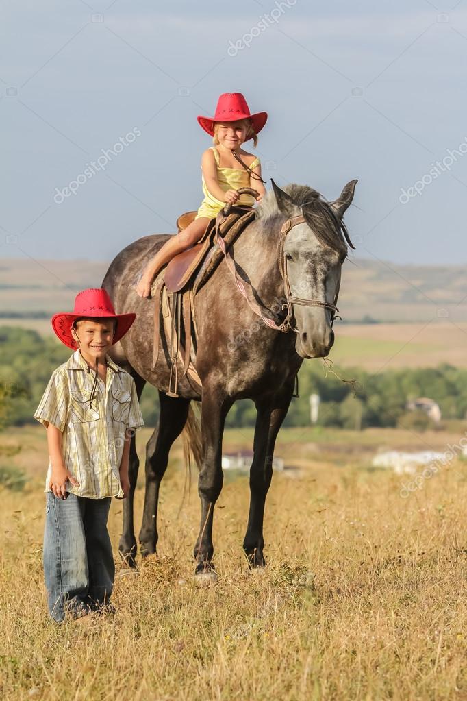 Two young happy kids riding a horse on farm, outdoor portrait on Stock ...
