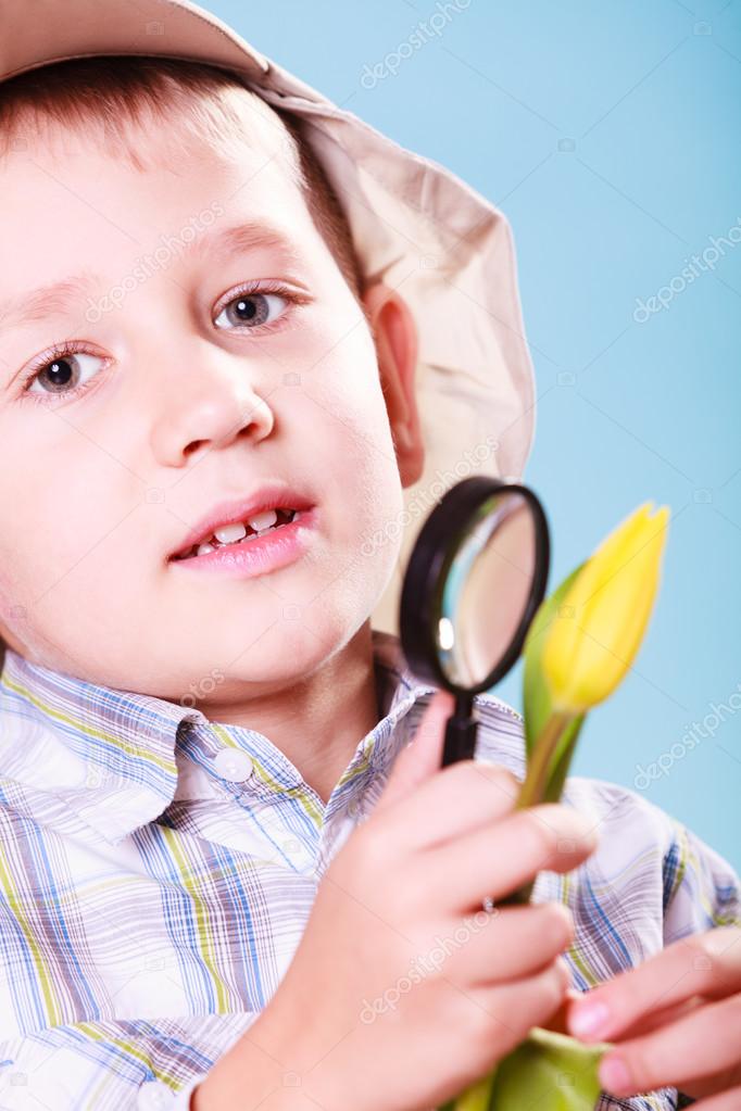 Young boy hold flower and magnifying glass. Stock Photo by ©Voyagerix ...