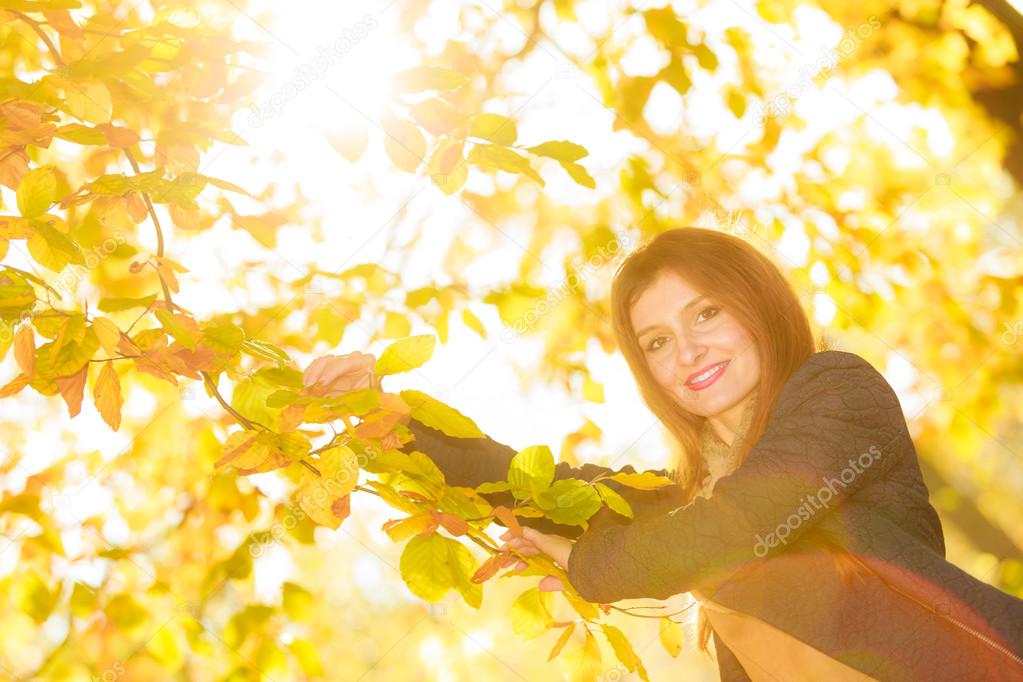 Attractive girl among trees and leaves Stock Photo by ©Voyagerix 112215830