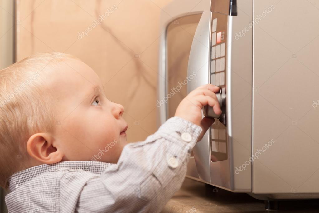 Boy playing with microwave oven — Stock Photo © Voyagerix #53951327