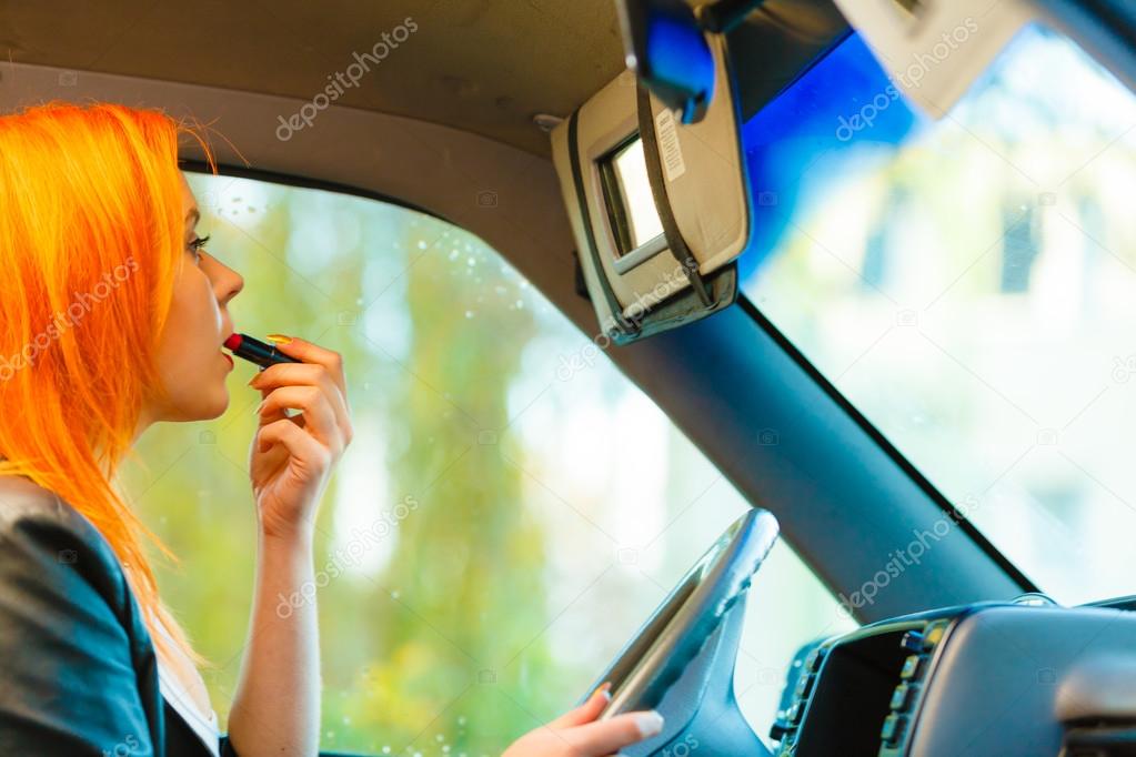 Girl doing makeup while driving car — Stock Photo © Voyagerix #55929013