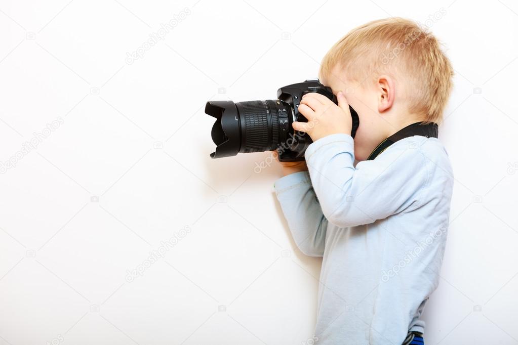 Child playing with camera Stock Photo by ©Voyagerix 59920201