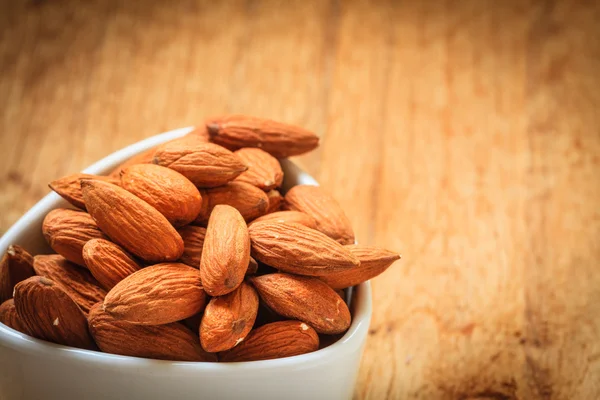 Almonds in white bowl — Stock Photo © Voyagerix #82525870