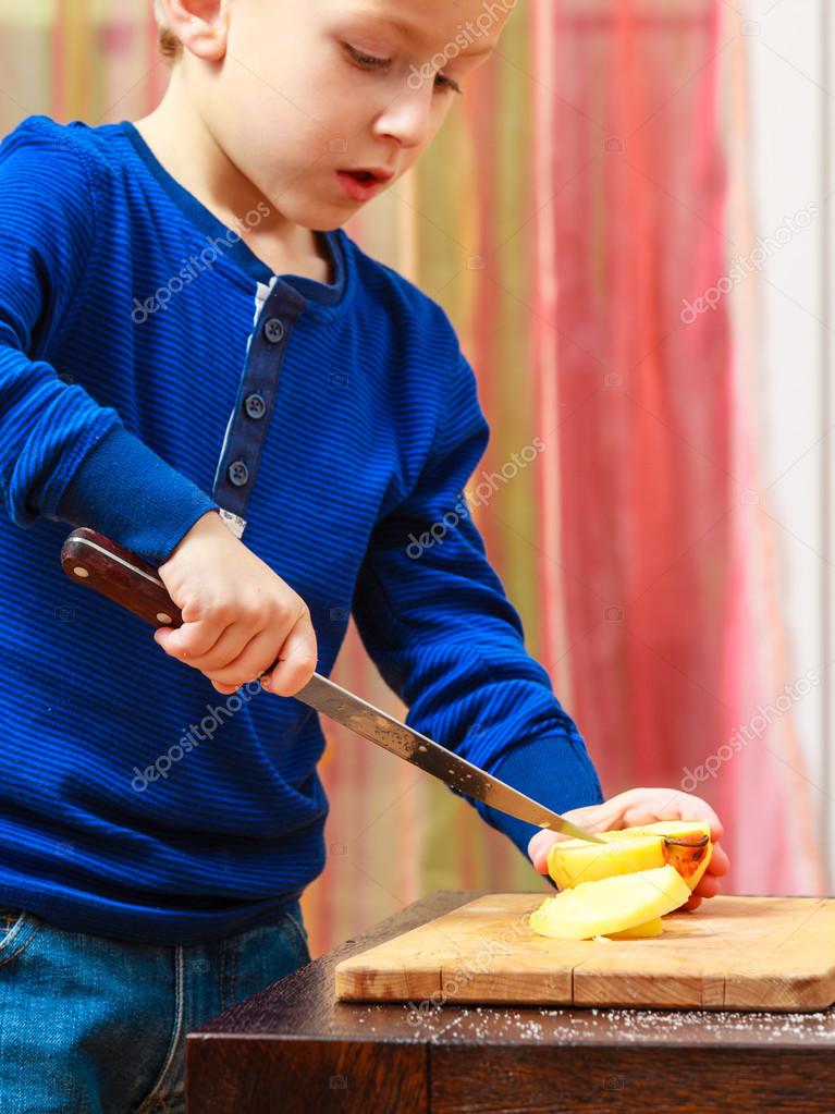 Child cutting apple with a kitchen knife Stock Photo by ©Voyagerix 68320533