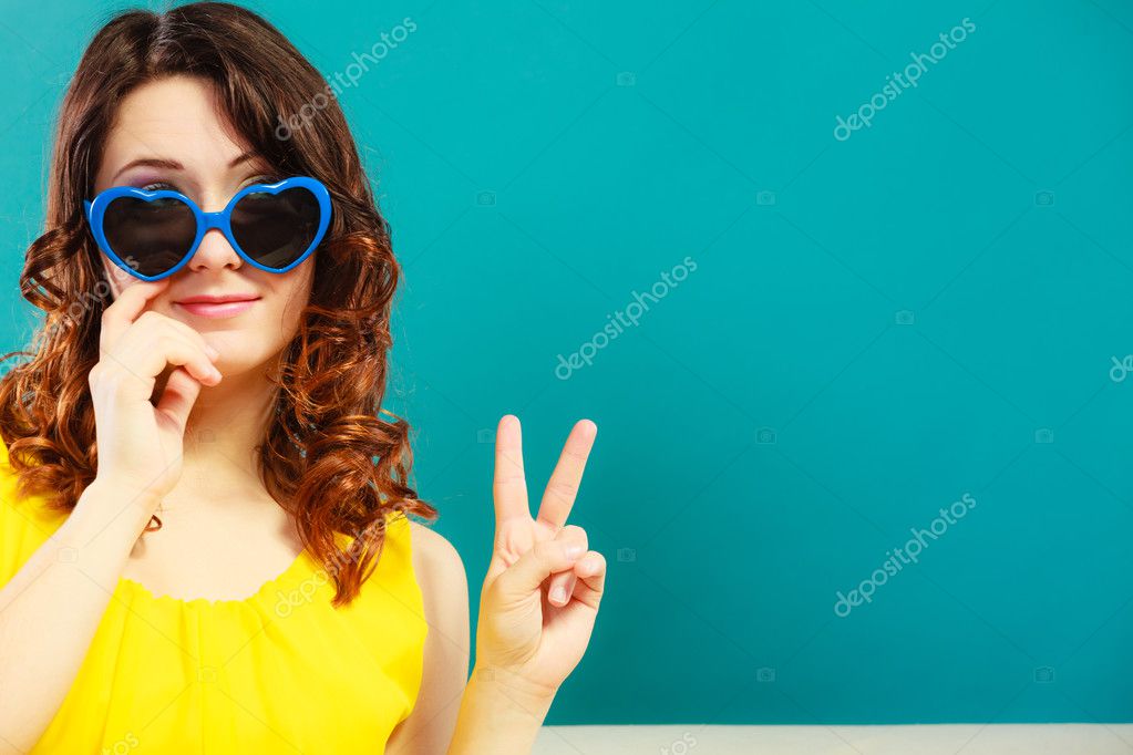 Girl making victory hand gesture Stock Photo by ©Voyagerix 70342657
