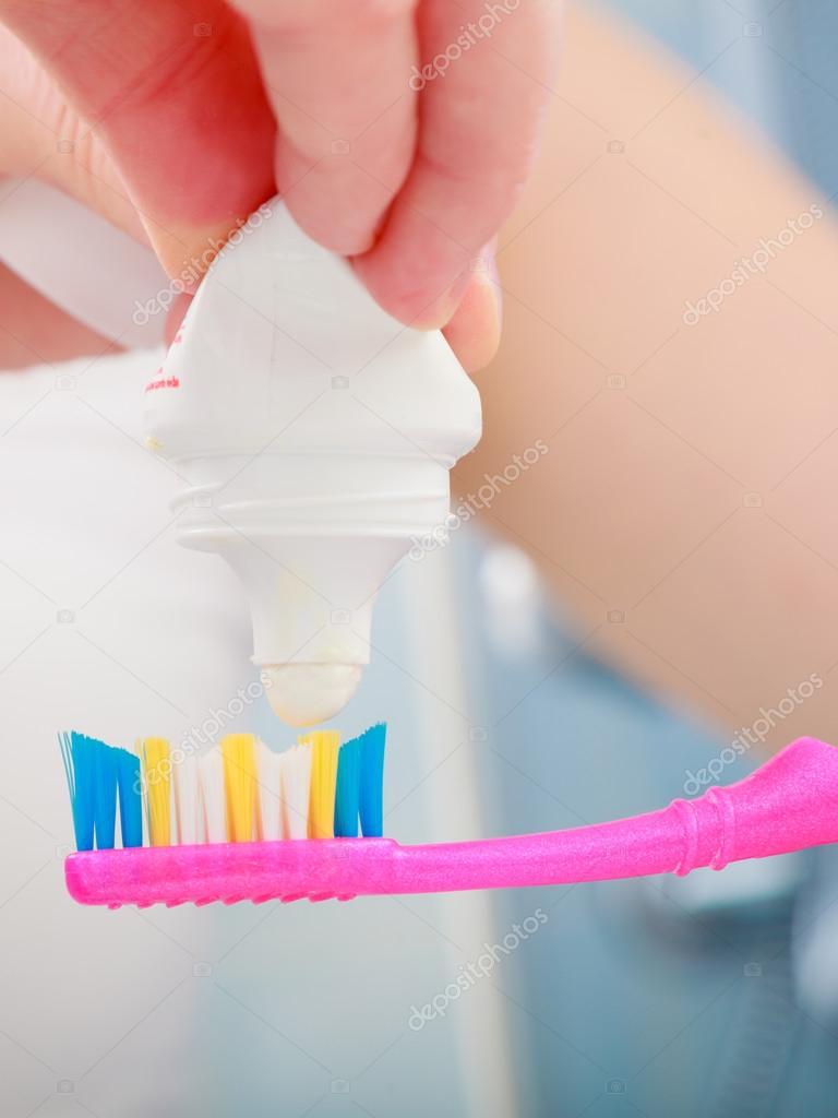 Woman hands putting toothpaste on toothbrush Stock Photo by ©Voyagerix ...