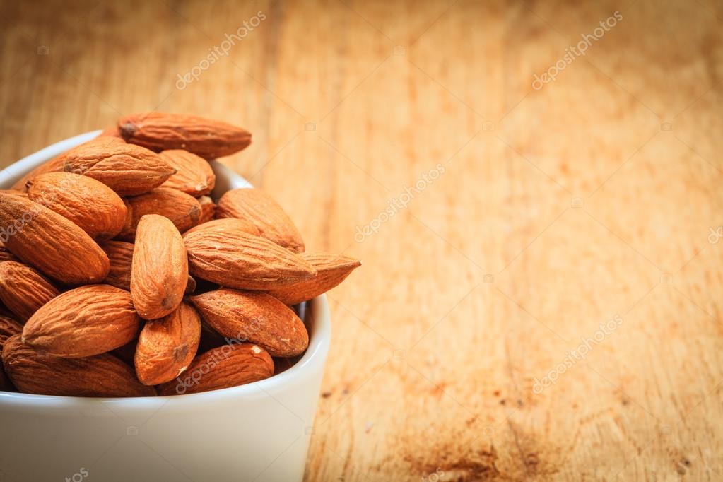 Almonds in white bowl — Stock Photo © Voyagerix #82525870
