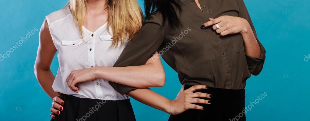 Dos mujeres cauc sicas y africanas cogidas de la mano. 2024