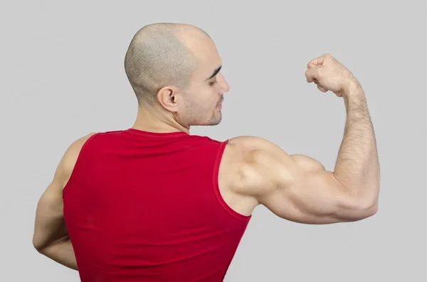 Pria botak yang kuat dengan perut, bahu, otot bisep, tongkat dan dada ...