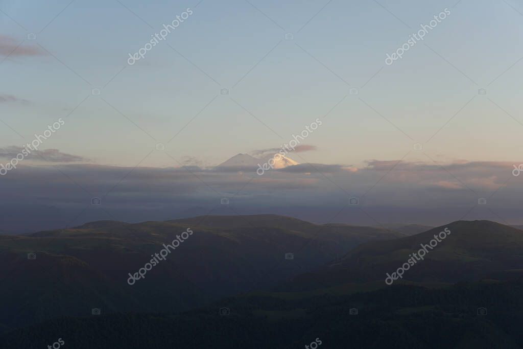 Vista de la montaña de Elbrus por encima de las nubes y la cordillera del Cáucaso con espigas ...