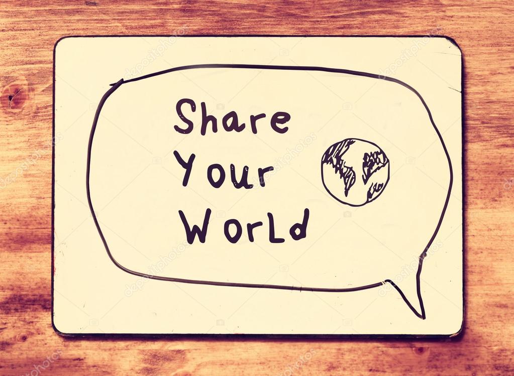 White board with the phrase share your world, over wooden textured ...