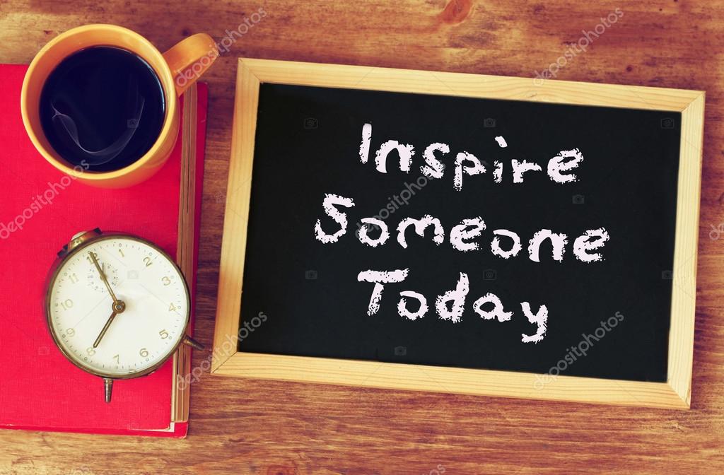 Black board with the phrase inspire someone today written on it. over ...