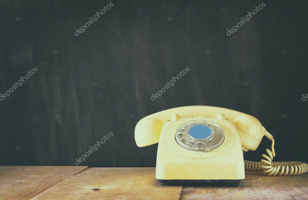 Retro telephone on wooden table. filtered image with faded retro style ...