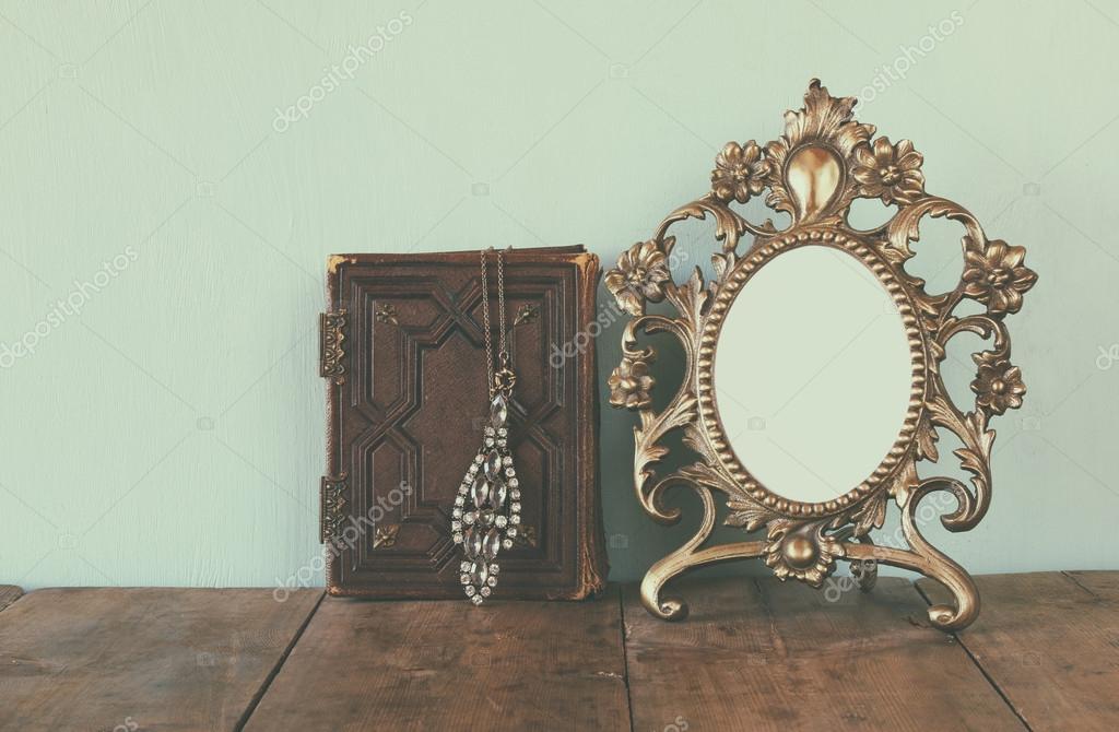 Antique blank victorian style frame and old book with vintage necklace ...