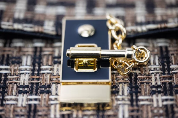 Close up of the lock of a ladies handbag. Fabric bag with gold clasp ...