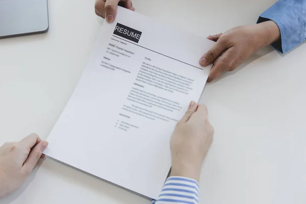 Applicants submitting a resume to the staff to apply for a job ...