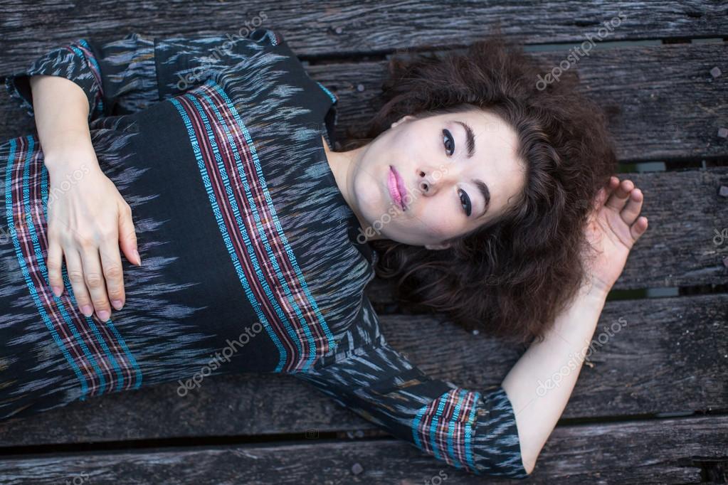 Hermosa mujer asiática tumbada en suelo de madera .: fotografía de ...