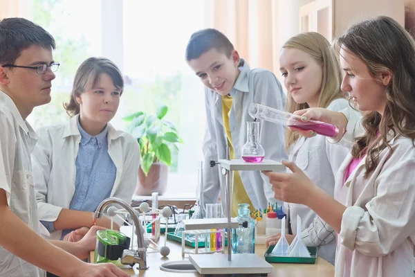 School children and their teacher in a high school science class ...