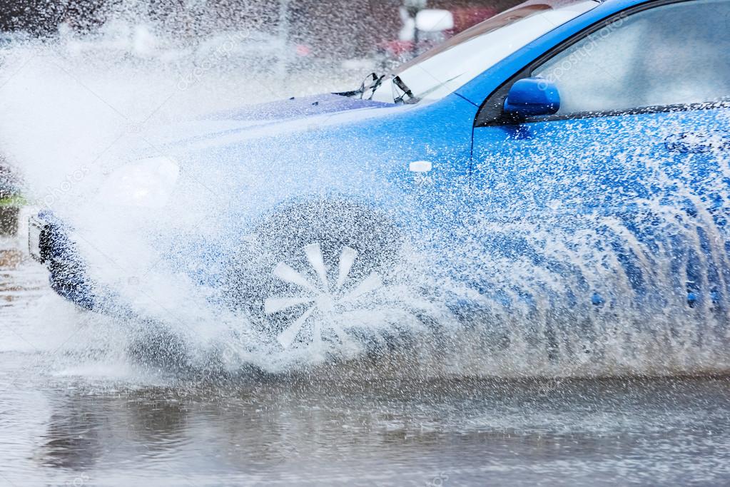 Car rain puddle splashing water Stock Photo by ©db-rus 106966904