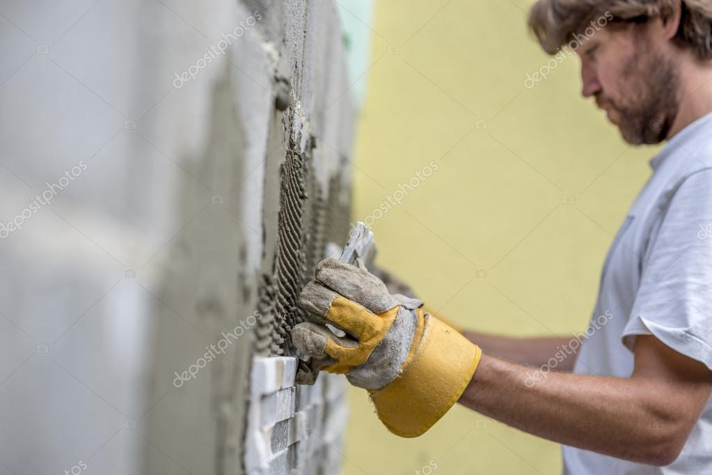Builder tiling a concrete wall — Stock Photo © Gajus-Images #79810590
