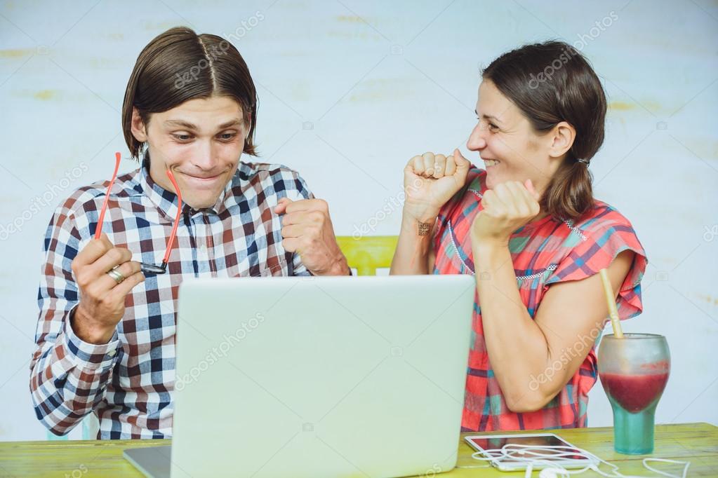 Surprised young nerd couple in glasses looking at computer monit Stock ...