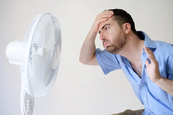 Flushed man feeling hot in front of a fan Stock Photo by ©tommaso1979 ...