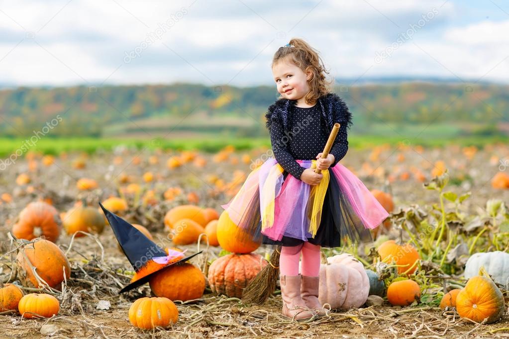 Little girl wearing halloween witch costume on pumpkin patch Stock ...
