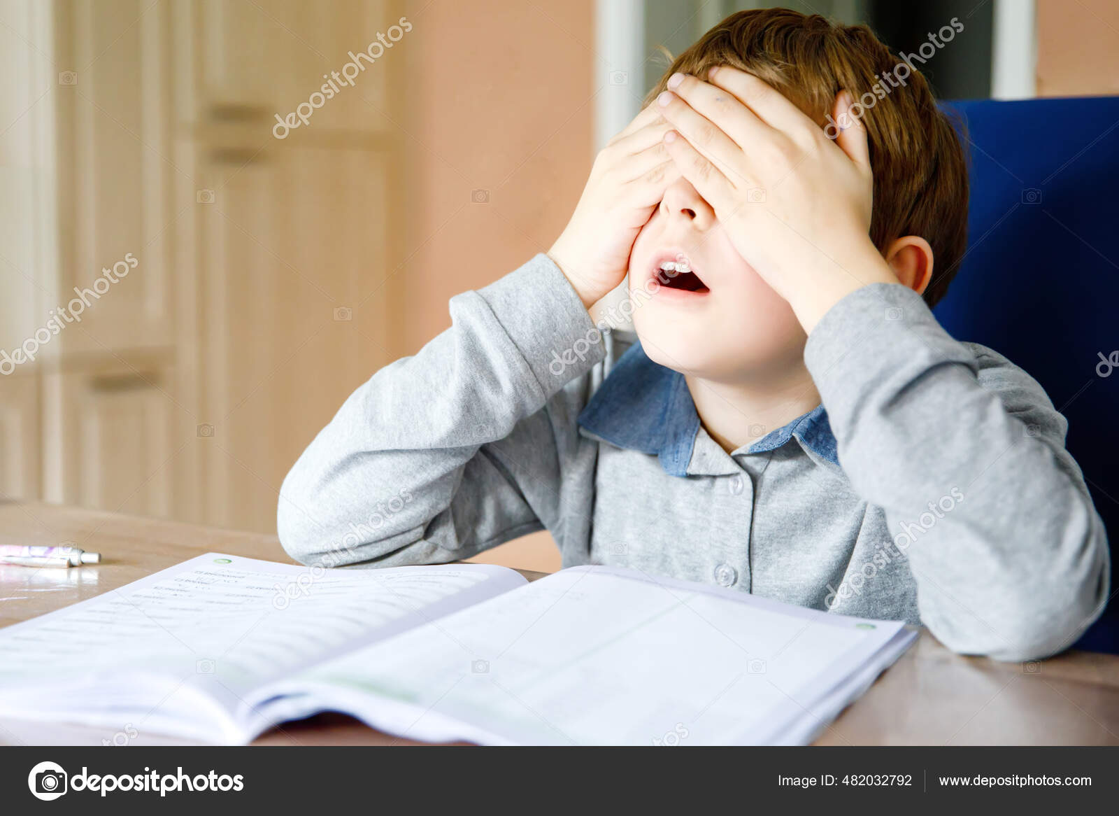 Upset school kid boy making homework during quarantine time from corona ...