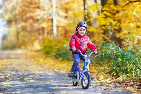 Kid jongen in helm met zijn eerste fiets, buitenshuis ⬇ Stockfoto ...