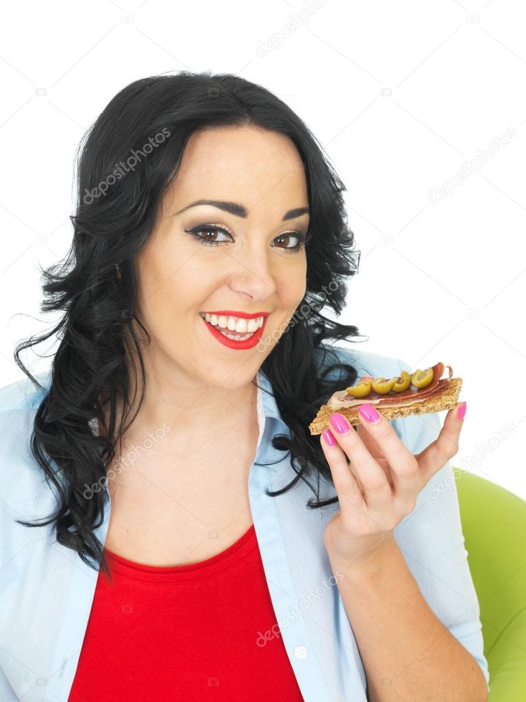 Healthy Woman Eating a Cracker with Parma Ham and Sliced Green Olives ...