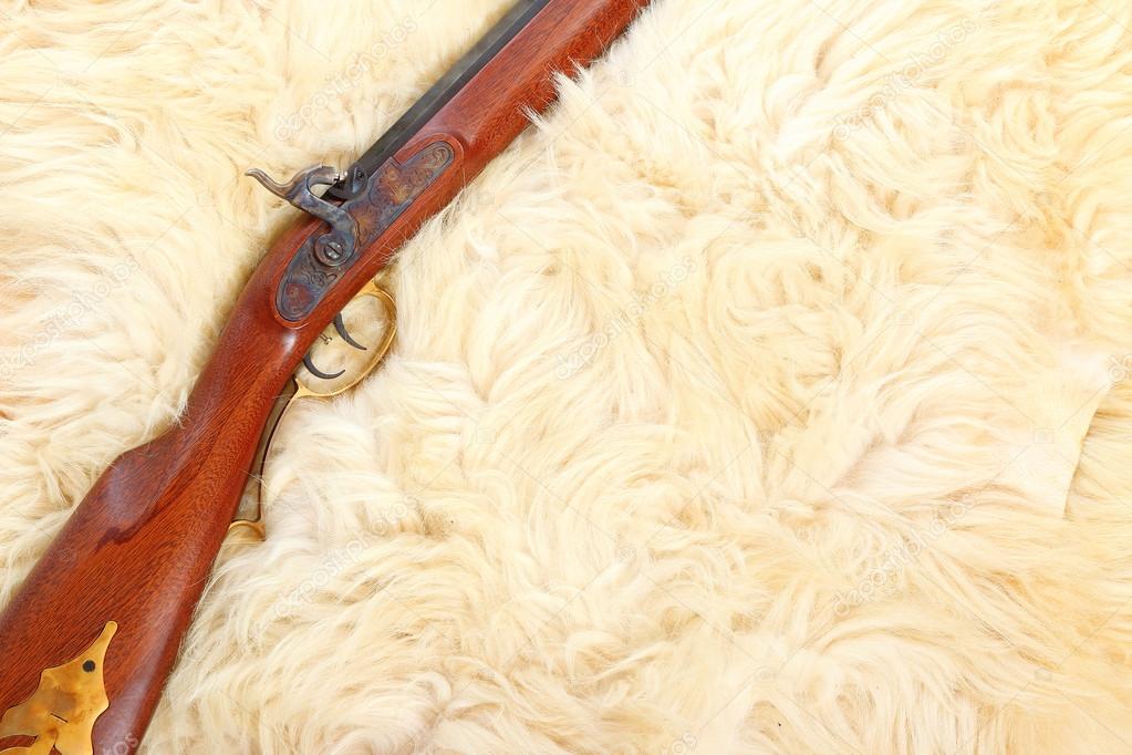 Hunting gun on a sheep fur. Stock Photo by ©vladvitek 65969657