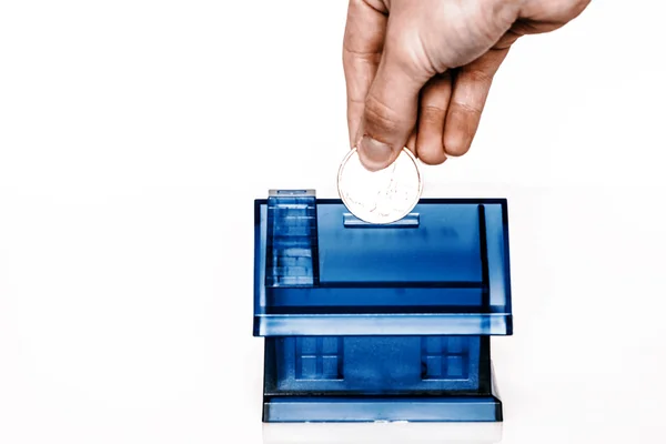 Blue House Money Box with man hand and coin on White Background Stock ...