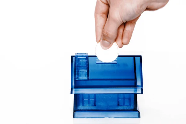 Blue House Money Box with man hand and coin on White Background Stock ...