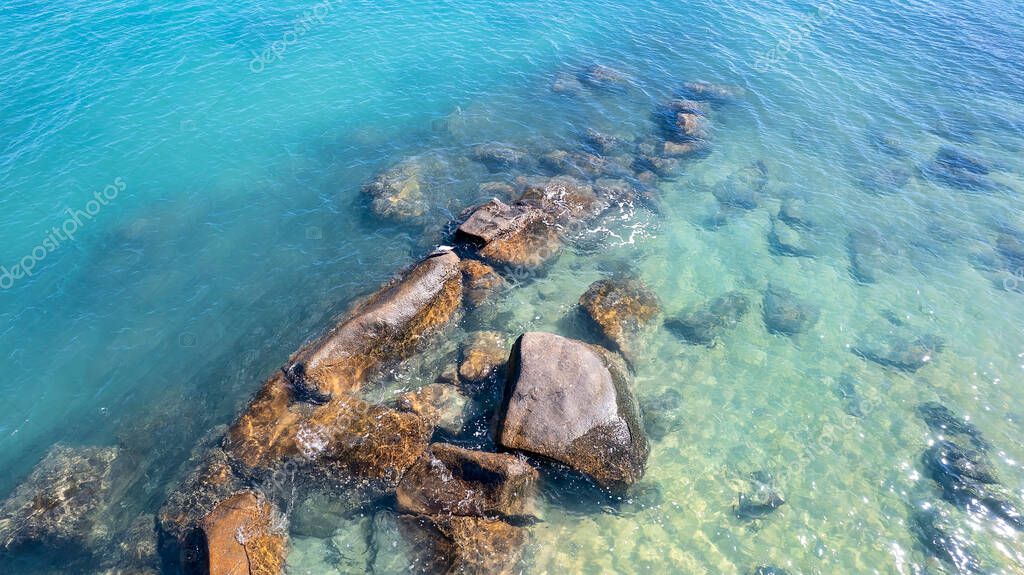 Vista aérea aérea de rocas justo fuera del agua a medida que la marea ...