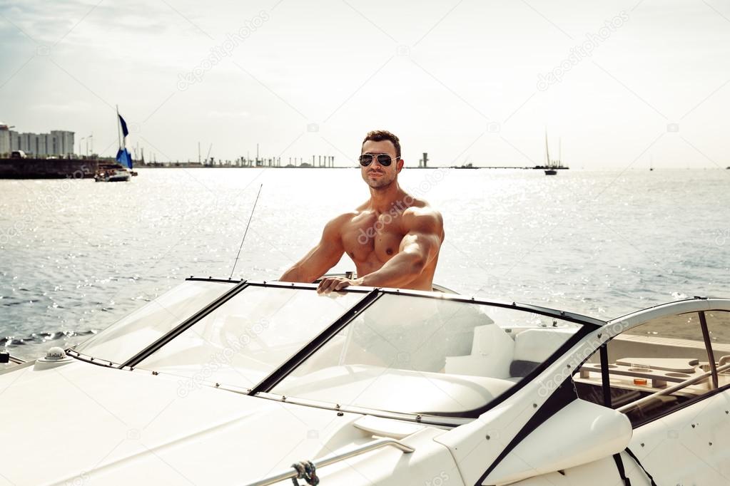 Muscle man on a boat Stock Photo by ©annamoskvina 107915962