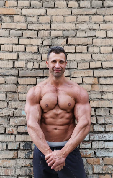 Muscular man on concrete background Stock Photo by ©annamoskvina 107950016