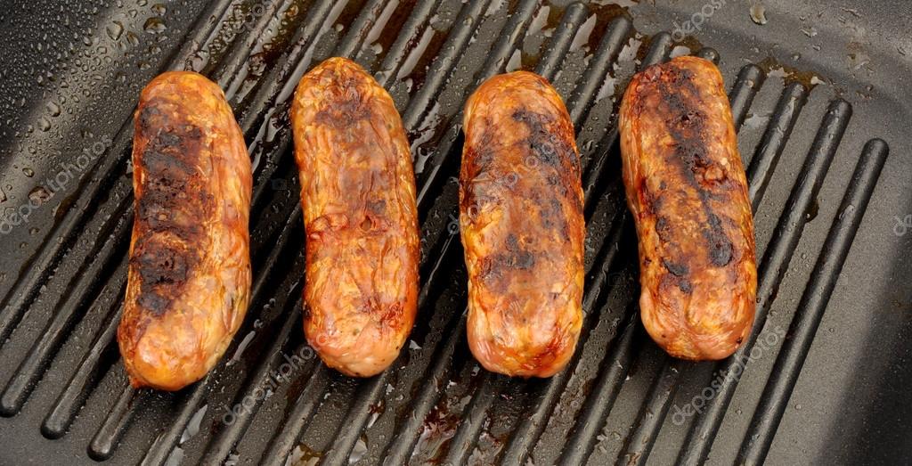 Embutidos de cerdo frito en una sartén de plancha 2024