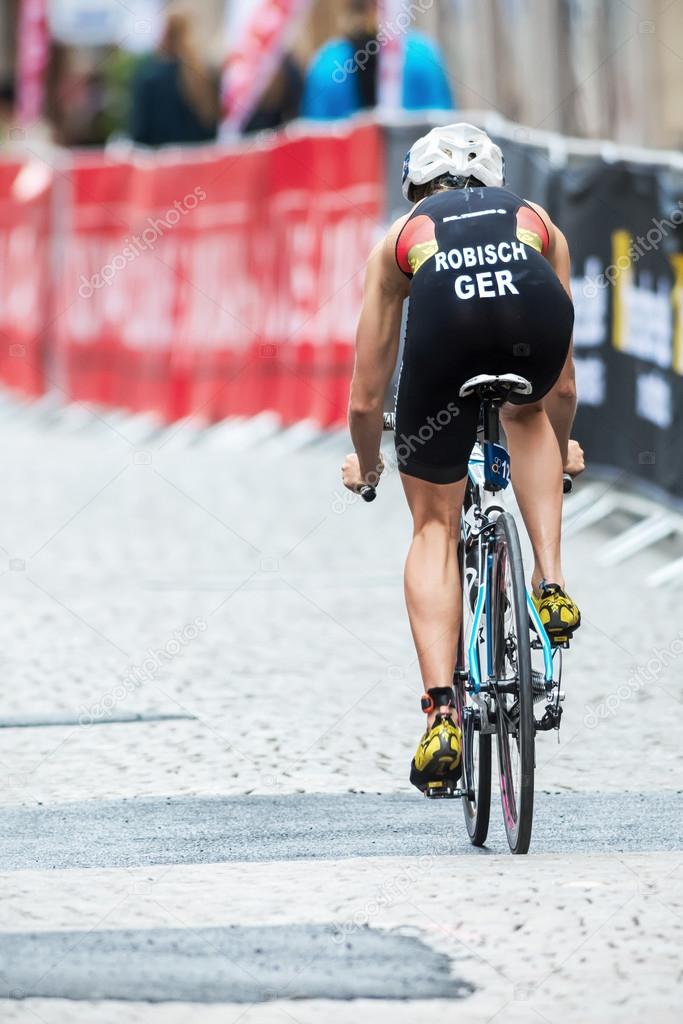 Back of Rebecca Robisch from Germany cycling in rain at the cobb ...