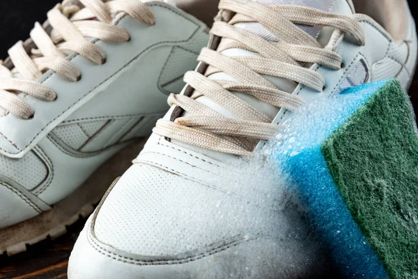 Sneakers in a wash basin with soapy water. Washing the dirty sneakers ...