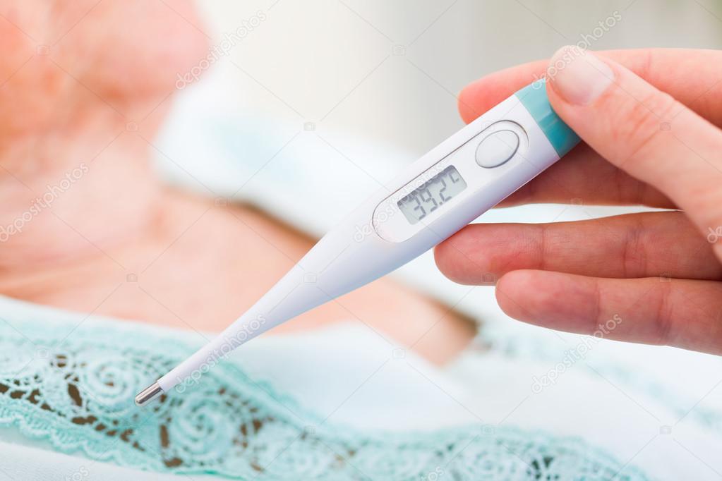 Nurse checking body temperature — Stock Photo © Lighthunter #104596666
